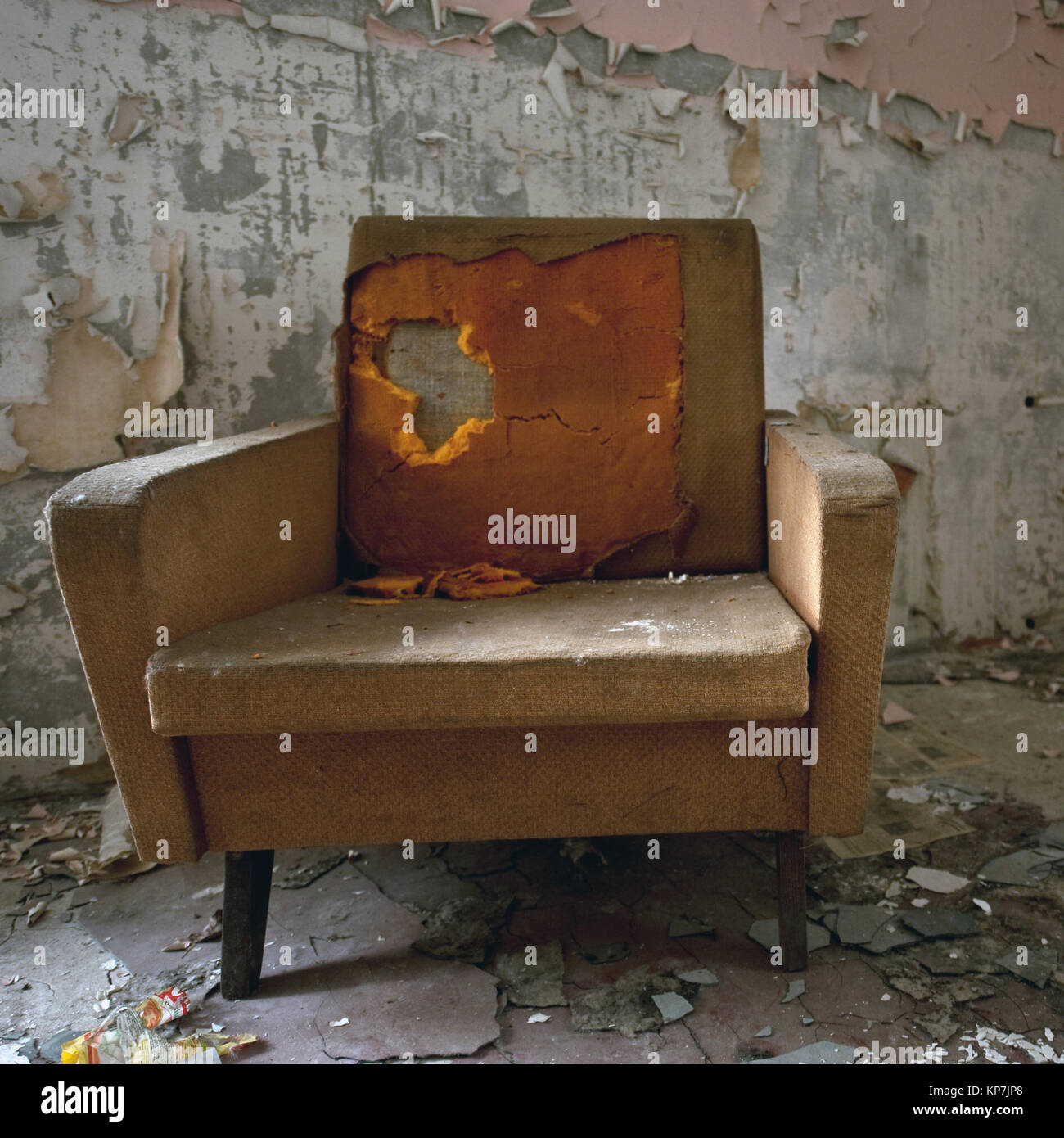 Old torn pink chair with a hole in the back in a ruined room in Pripyat ...