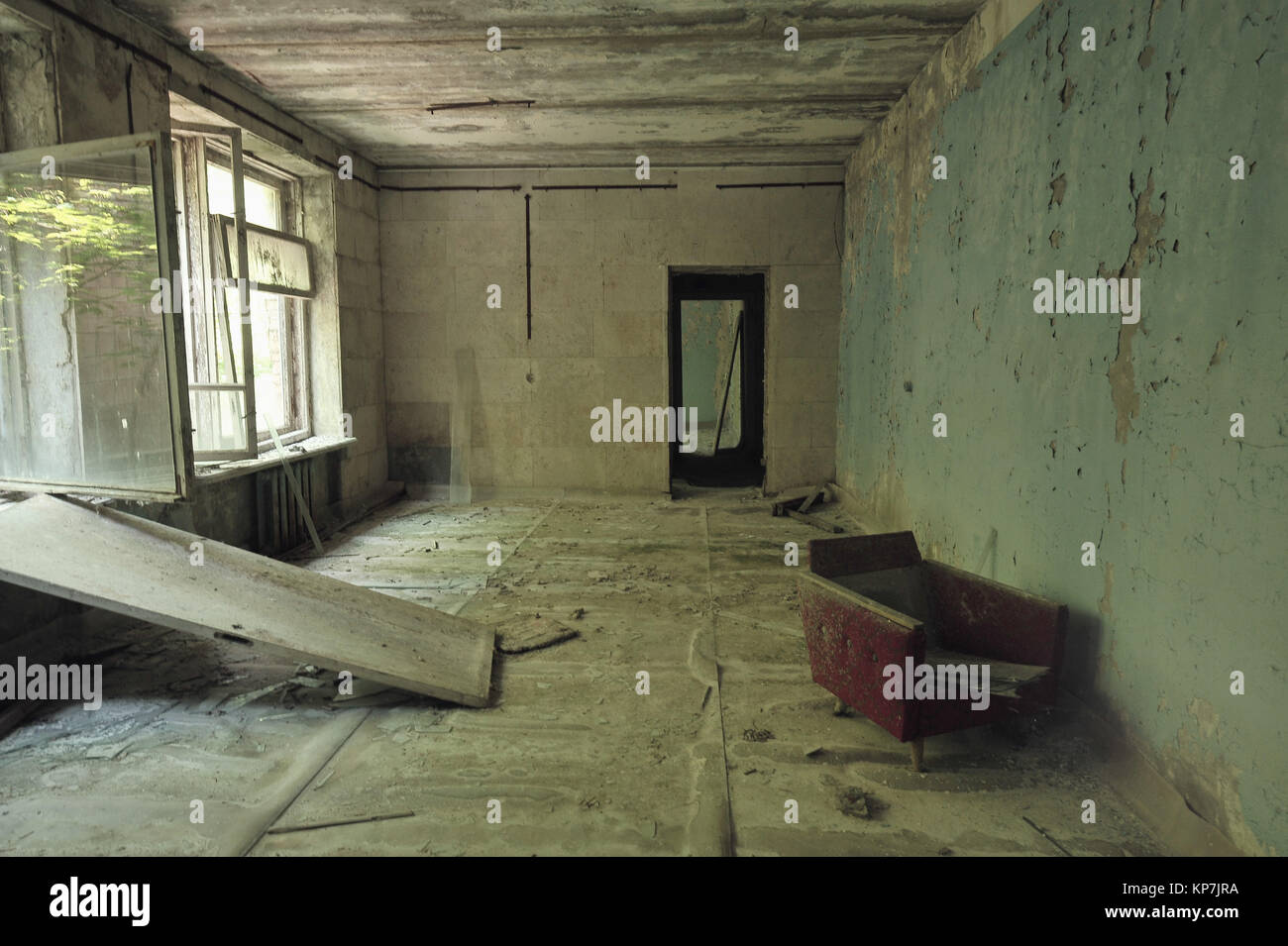 Ruined room in the abandoned house in Pripyat, red armchair near the ...
