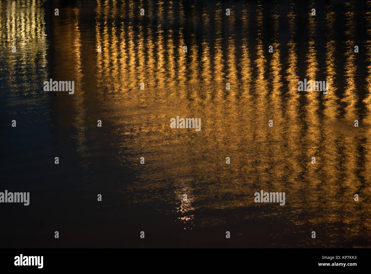 Reflection of night lights, bright yellow stripes of color on black ...