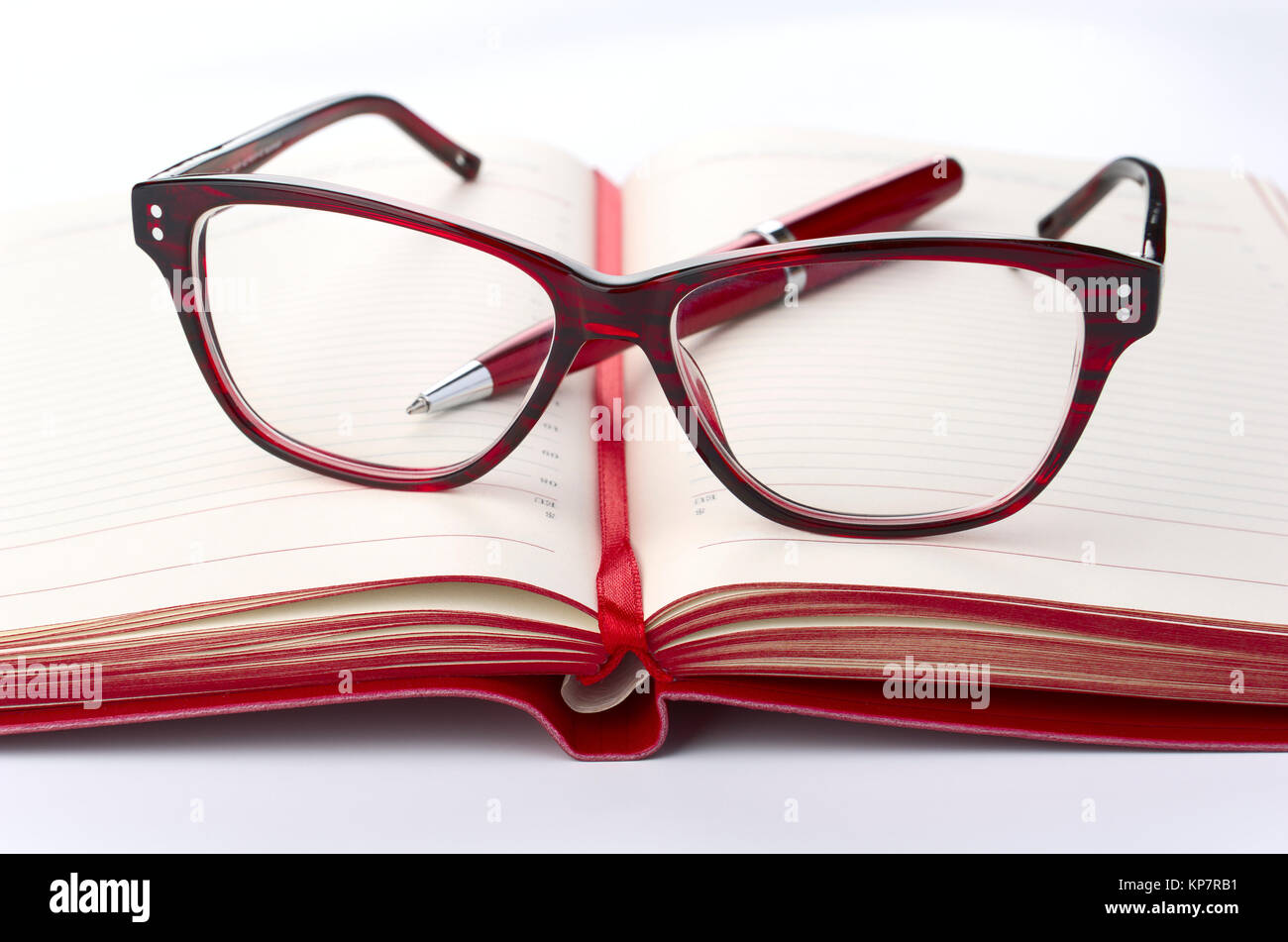 Red Daily planner with eyeglasses and pen, closeup Stock Photo - Alamy