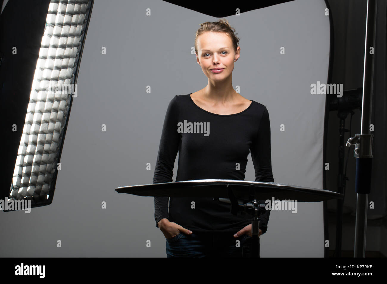 Beautiful female model posing in a photographic studio surrounded by ...