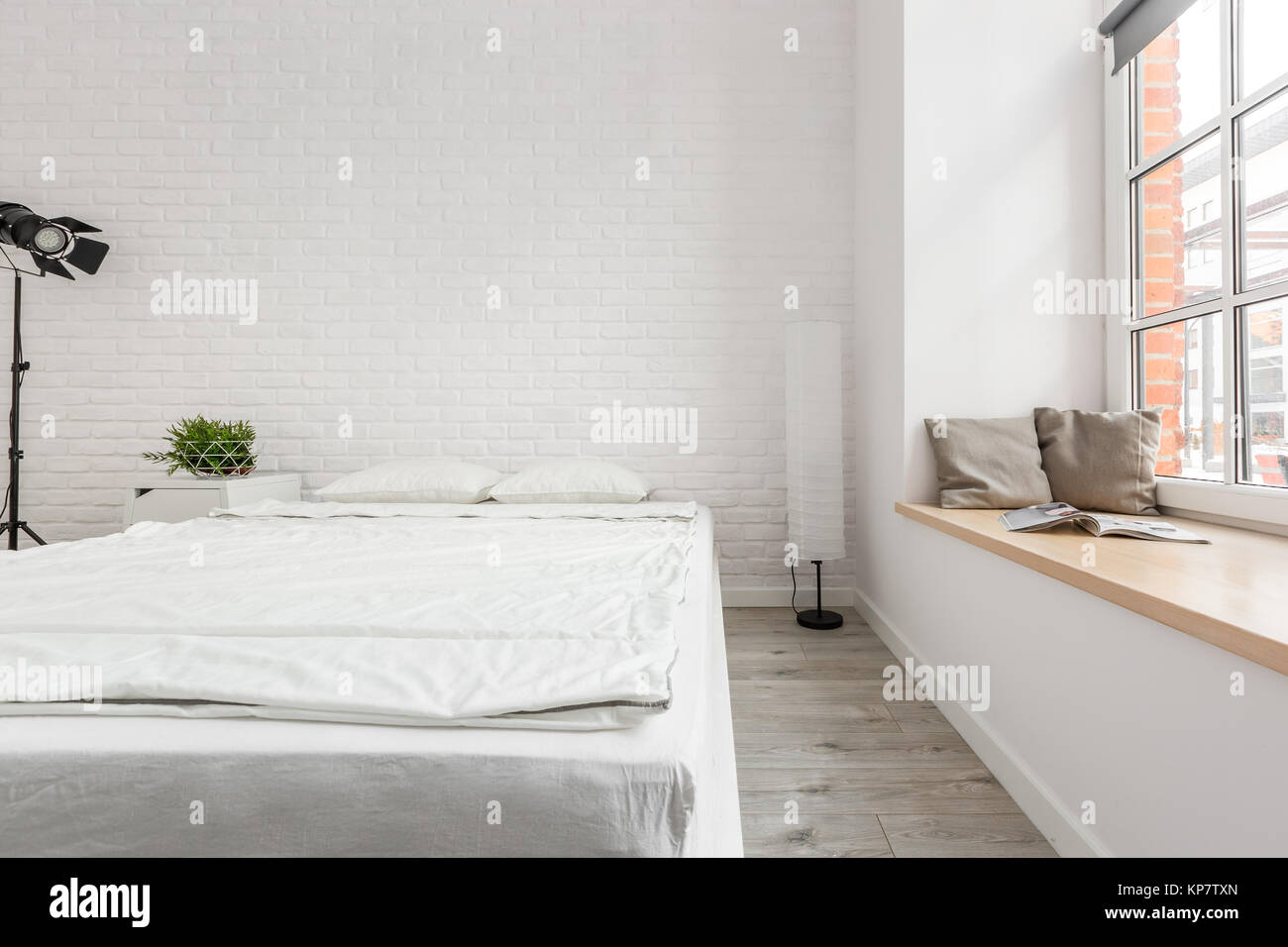 White brick wall in loft bedroom with big window Stock Photo - Alamy