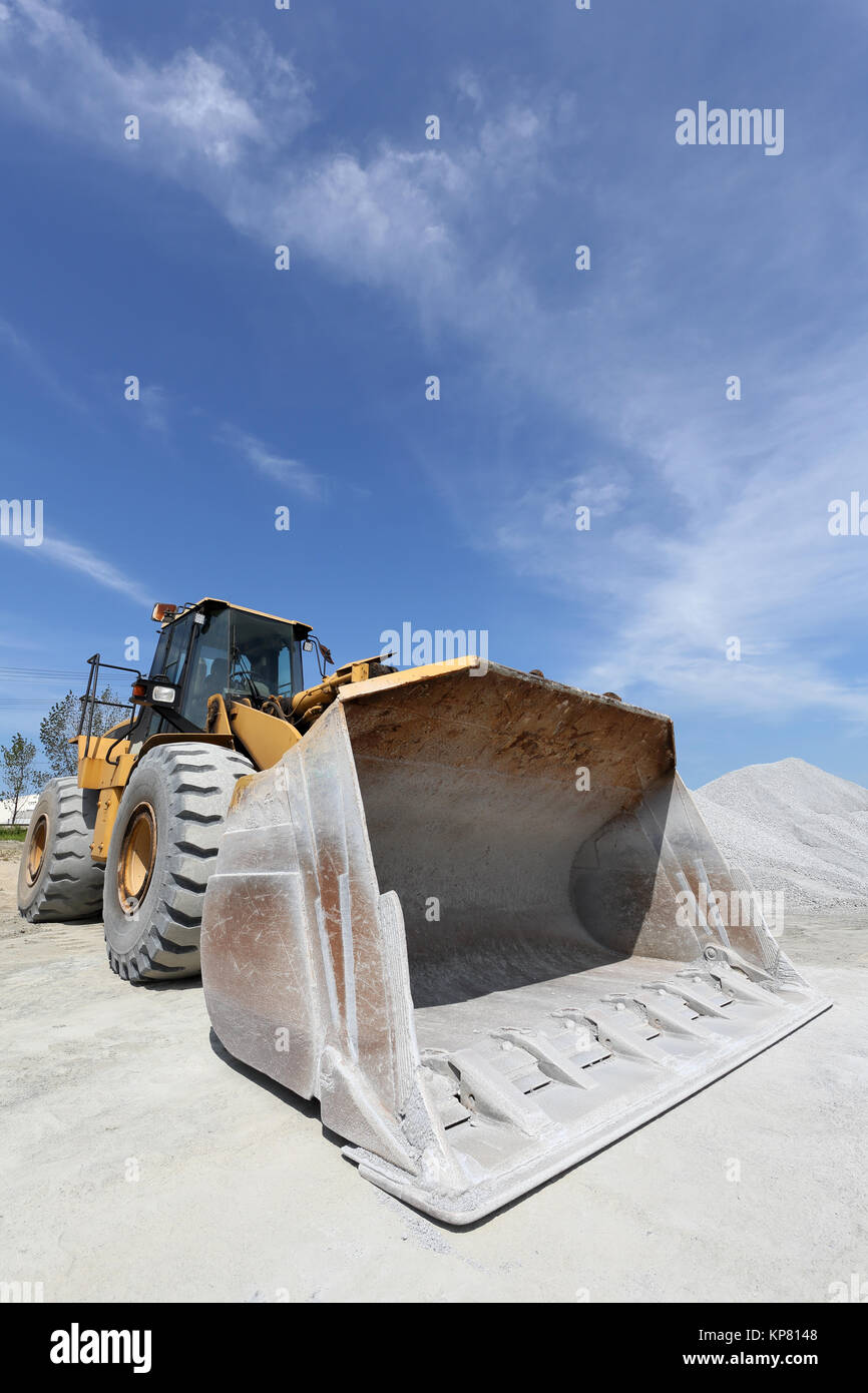 Bulldozer with sand mound against a blue sky Stock Photo - Alamy