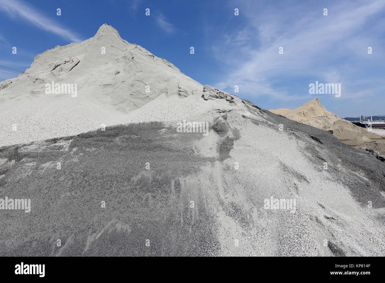Gray sand mound against blue sky Stock Photo - Alamy