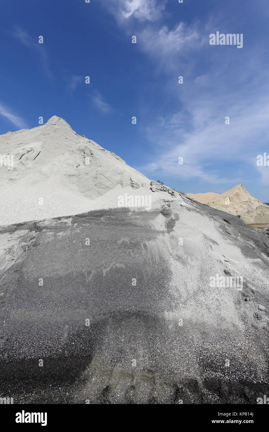 Gray sand mound against blue sky Stock Photo - Alamy