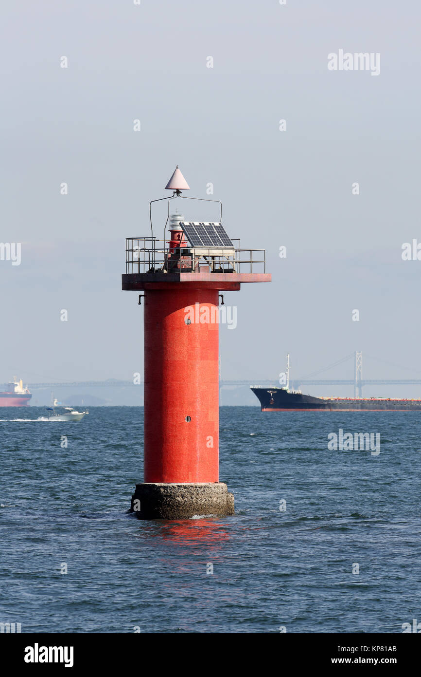 lighthouse with cargo ship in the sea Stock Photo - Alamy