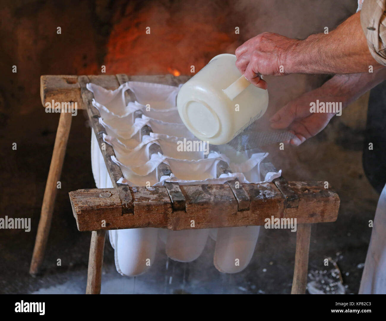 old cheesemaker during the preparation of the cheese in the cheese ...