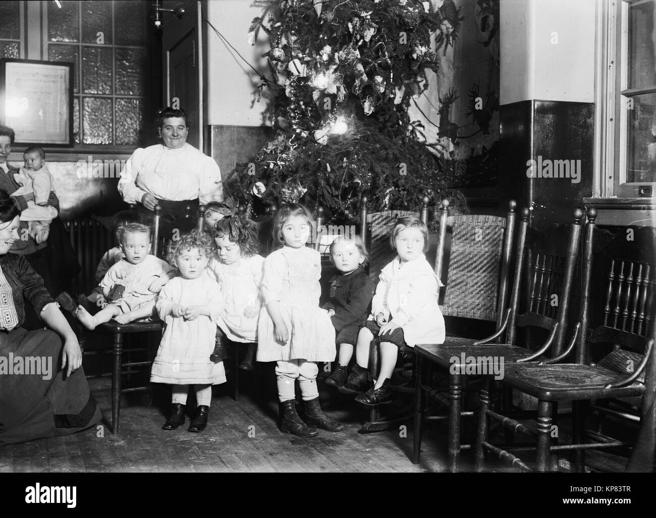 Children in the early 1900s sitting in front of Christmas tree Stock ...