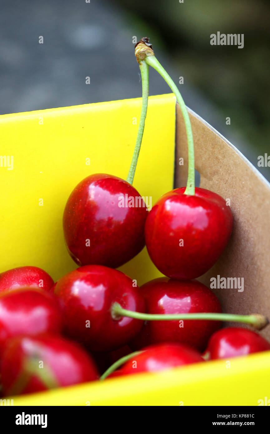 Cherries in a yellow box on a garden wall Stock Photo - Alamy