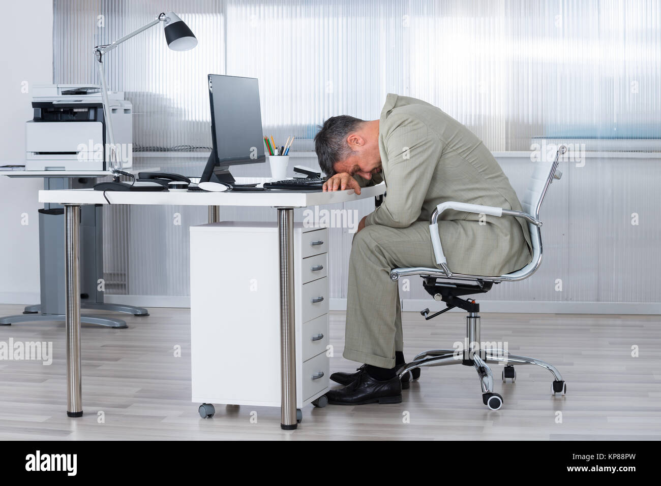 Businessman Sleeping On Desk In Office Stock Photo - Alamy