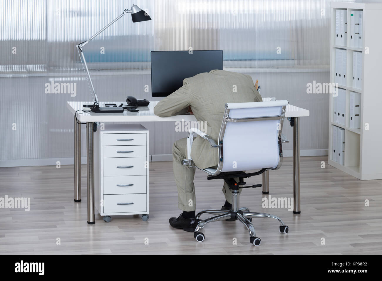 Tired Businessman Sleeping On Desk In Office Stock Photo - Alamy