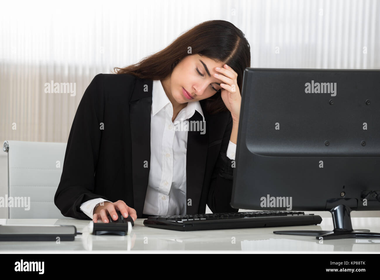 Businesswoman Sitting With Head In Hand At Computer Desk Stock Photo ...