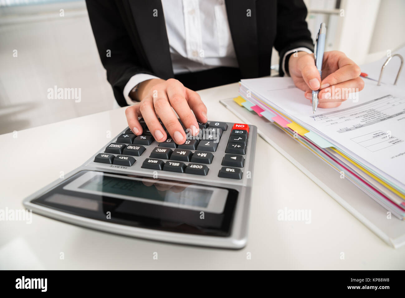 Businesswoman Doing Financial Calculation At Desk Stock Photo - Alamy