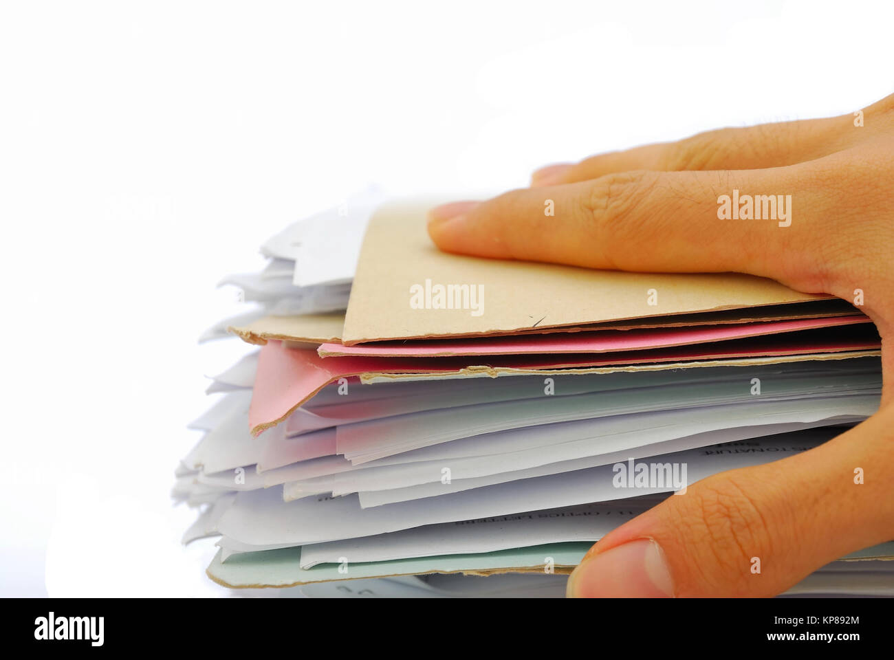 Hand on a stack of files full of documents signifying concepts such as ...