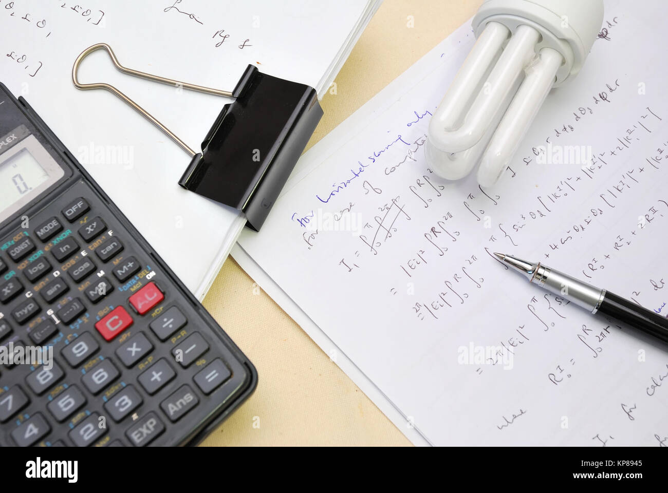 Documents and notes on math equations with light bulb signifying ...