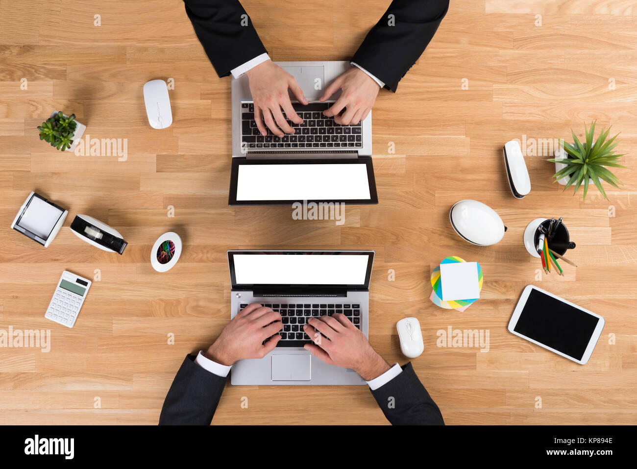 Businessmen Using Laptops At Desk Stock Photo - Alamy