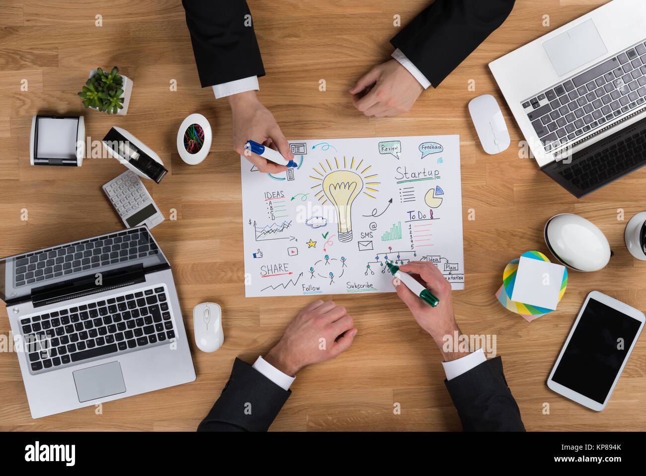 Businessmen Making Strategy At Wooden Desk Stock Photo - Alamy