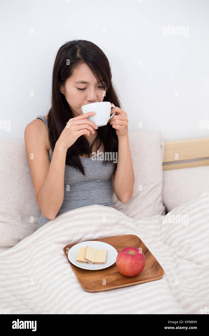Young Woman having morning breakfast on bed Stock Photo - Alamy