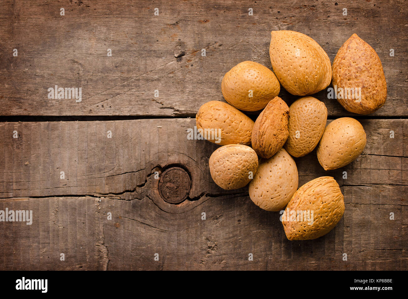 Almonds on a rustic wooden table with space for text Stock Photo - Alamy