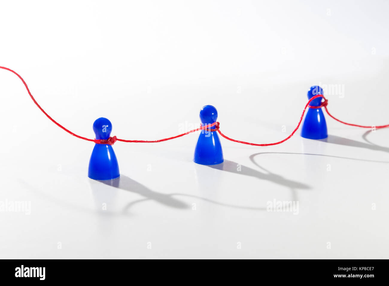 Three figures connected with a rope Stock Photo - Alamy