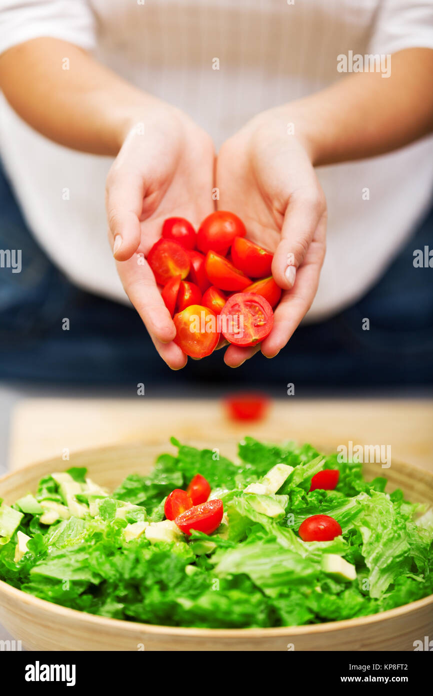 Young woman making salad Stock Photo - Alamy