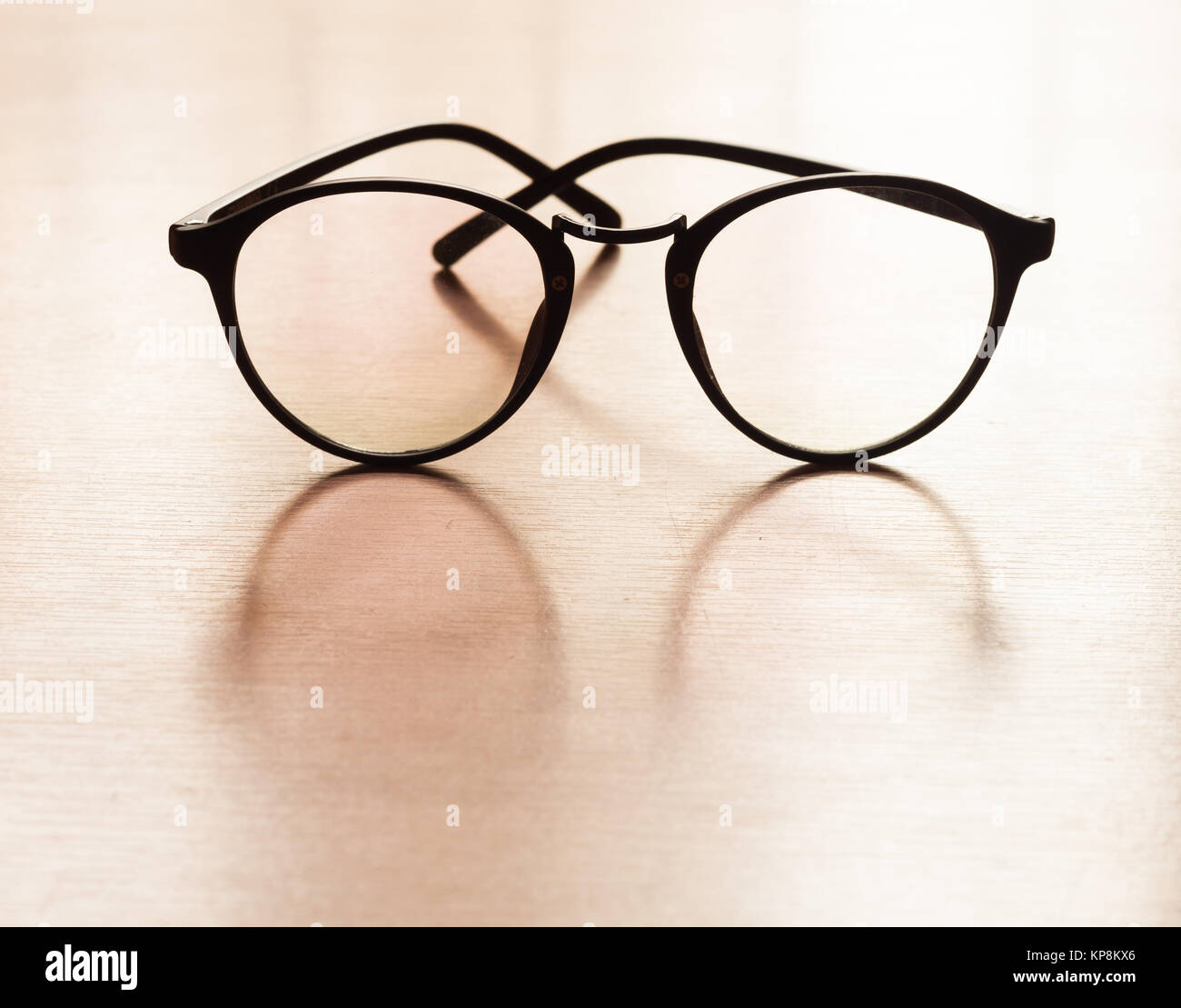 Eyeglasses with reflection on wooden table Stock Photo - Alamy