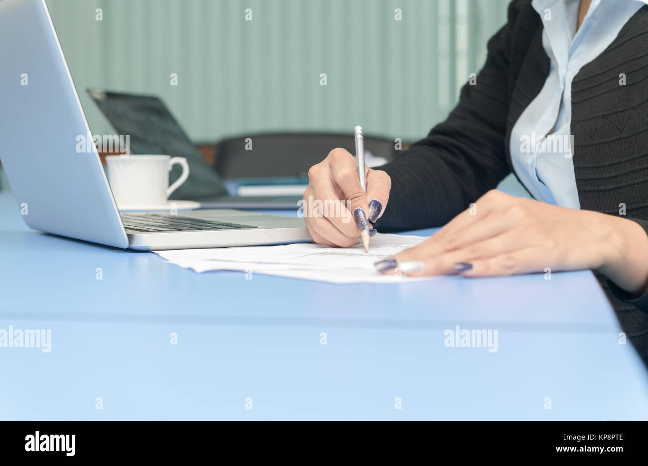 Hands of financial manager taking notes when working on report in ...