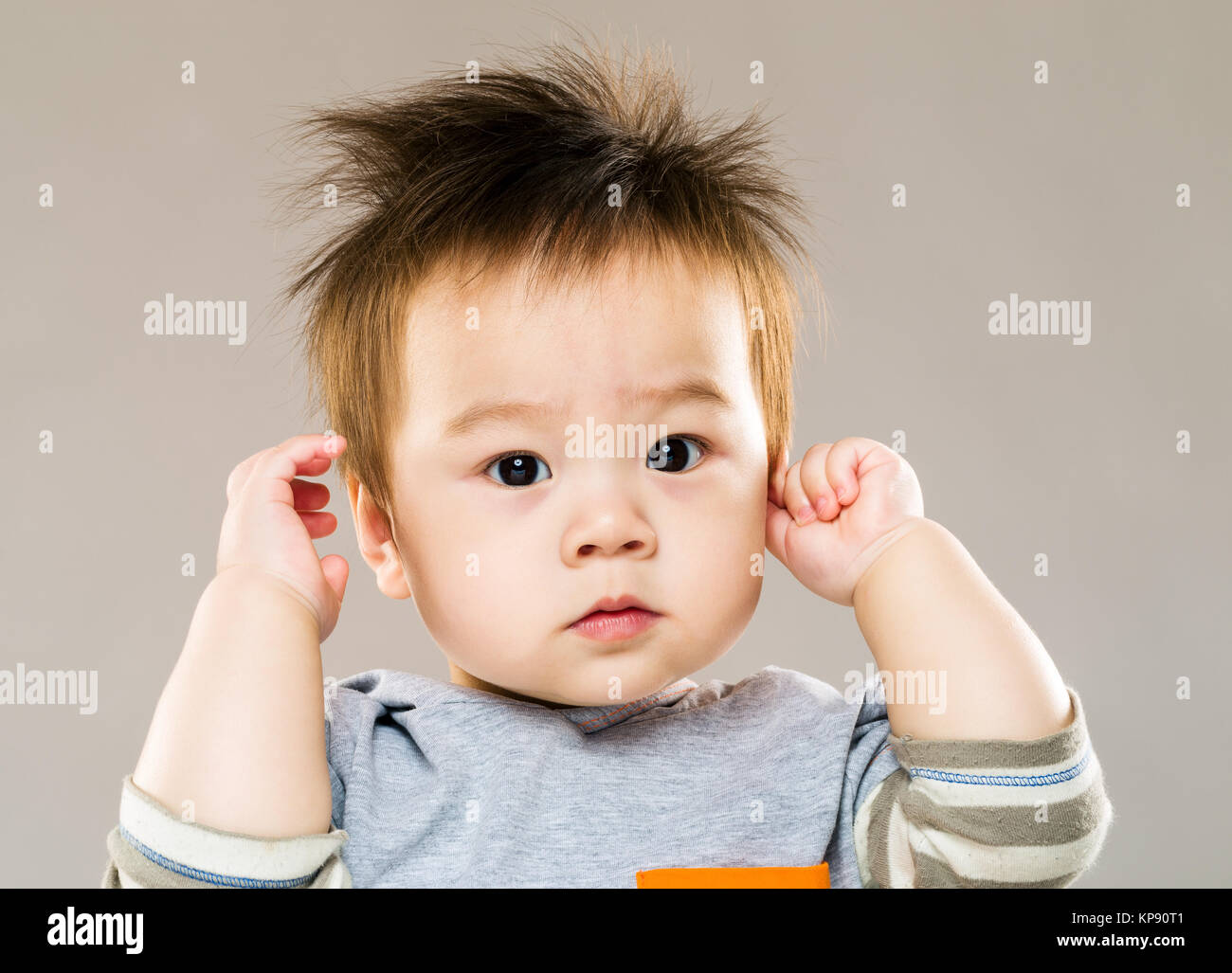 Sweet little boy with hand touch ear Stock Photo - Alamy