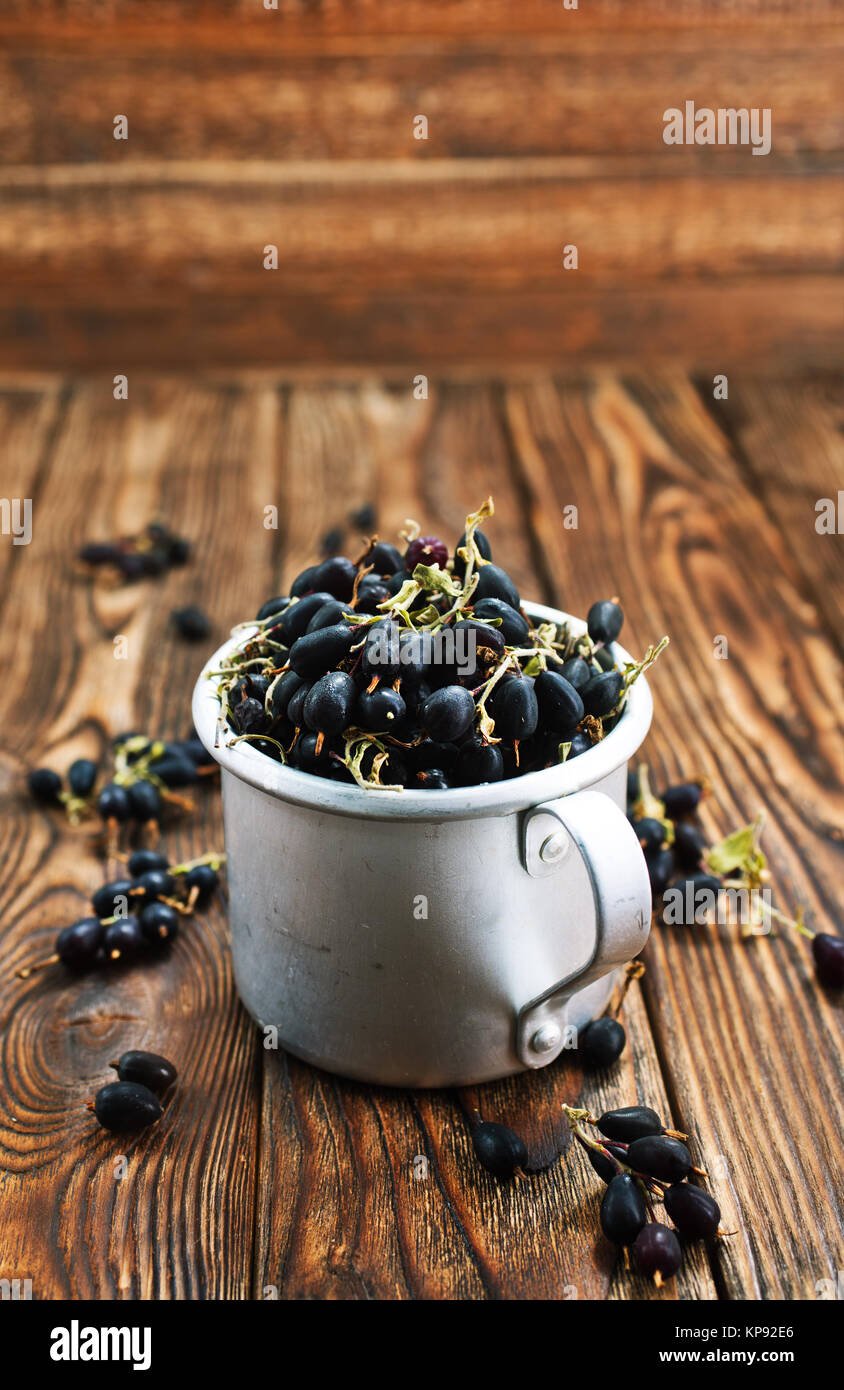 black currant in metal cup and on a table Stock Photo - Alamy