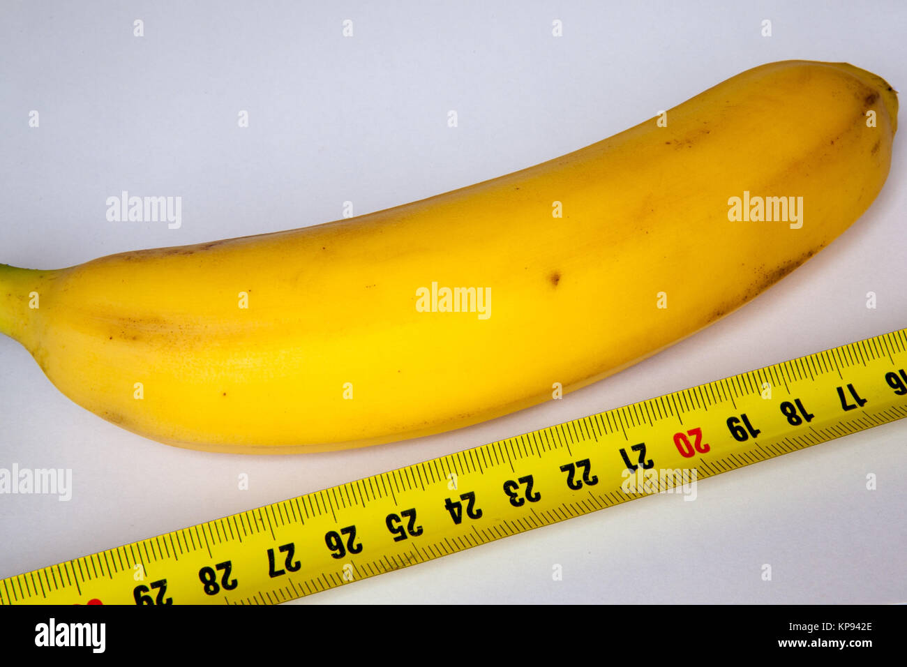 Diet concept. Banana with measuring tape closeup on white background ...