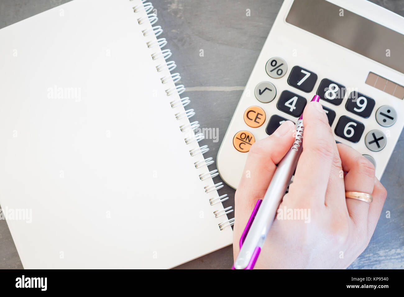 Hand with calculator and notepad Stock Photo - Alamy