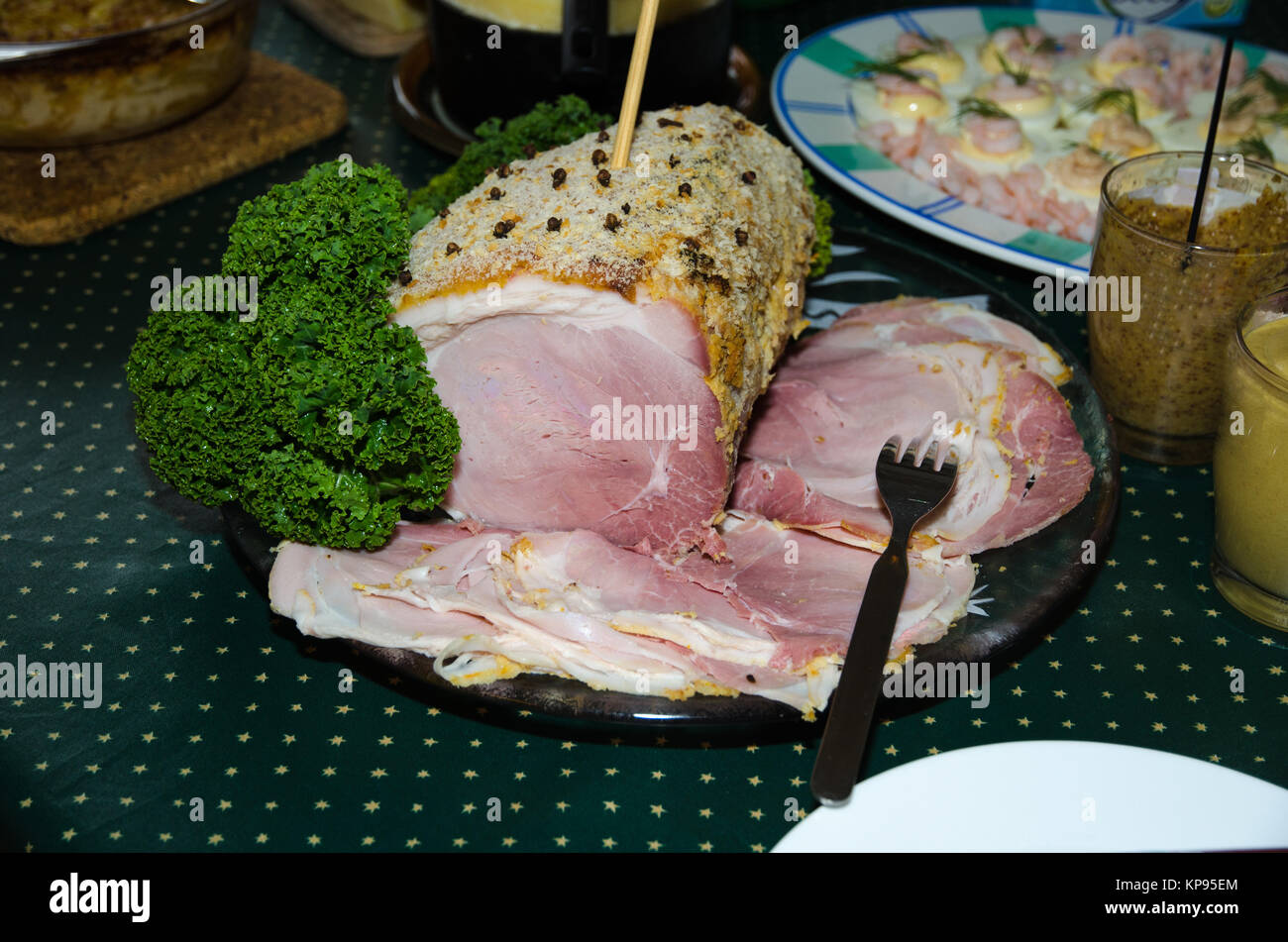Decorated and sliced christmas ham on a plate at a table Stock Photo ...