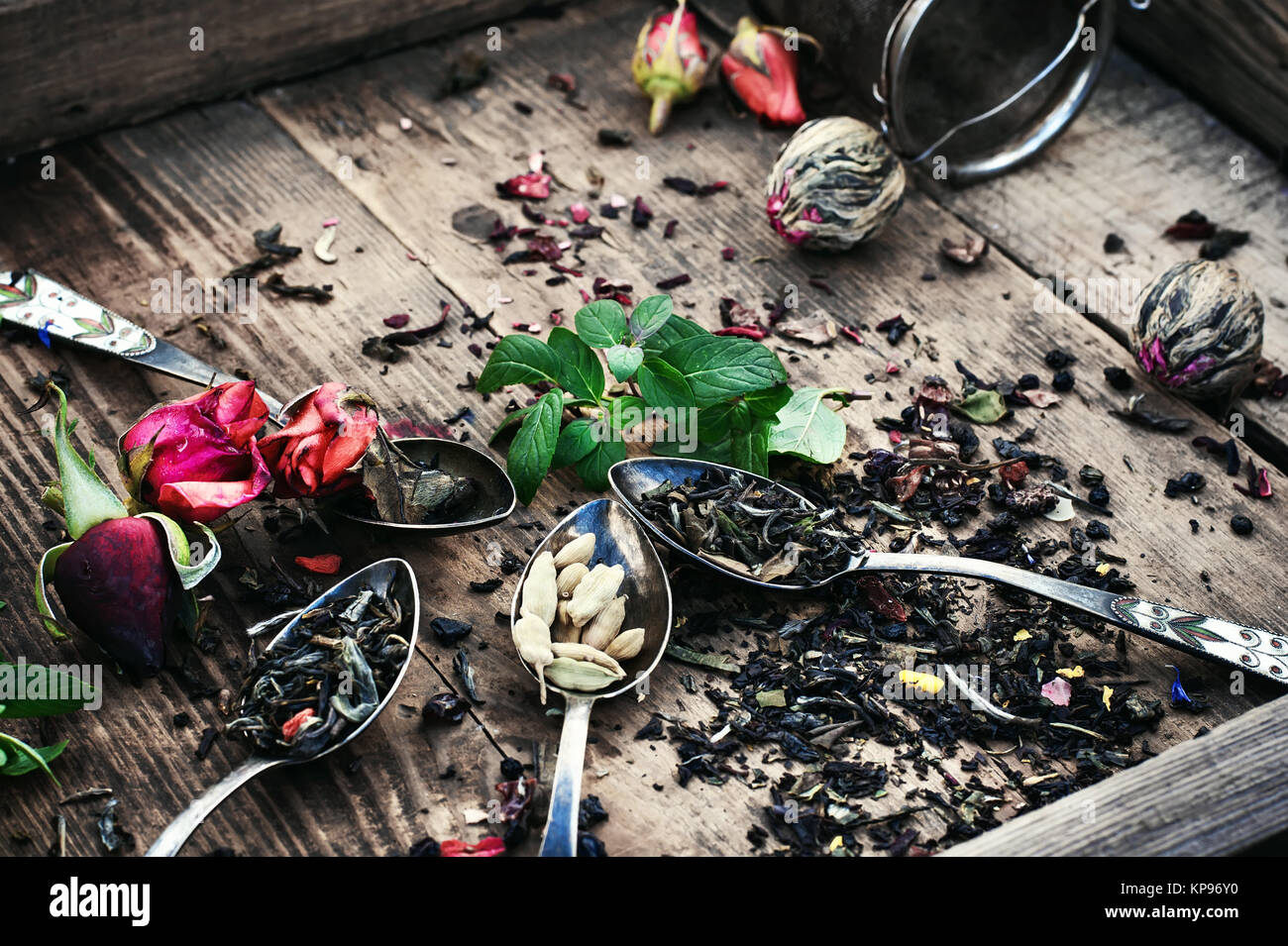 Spoon and spilling the tea leaves of different varieties on retro ...