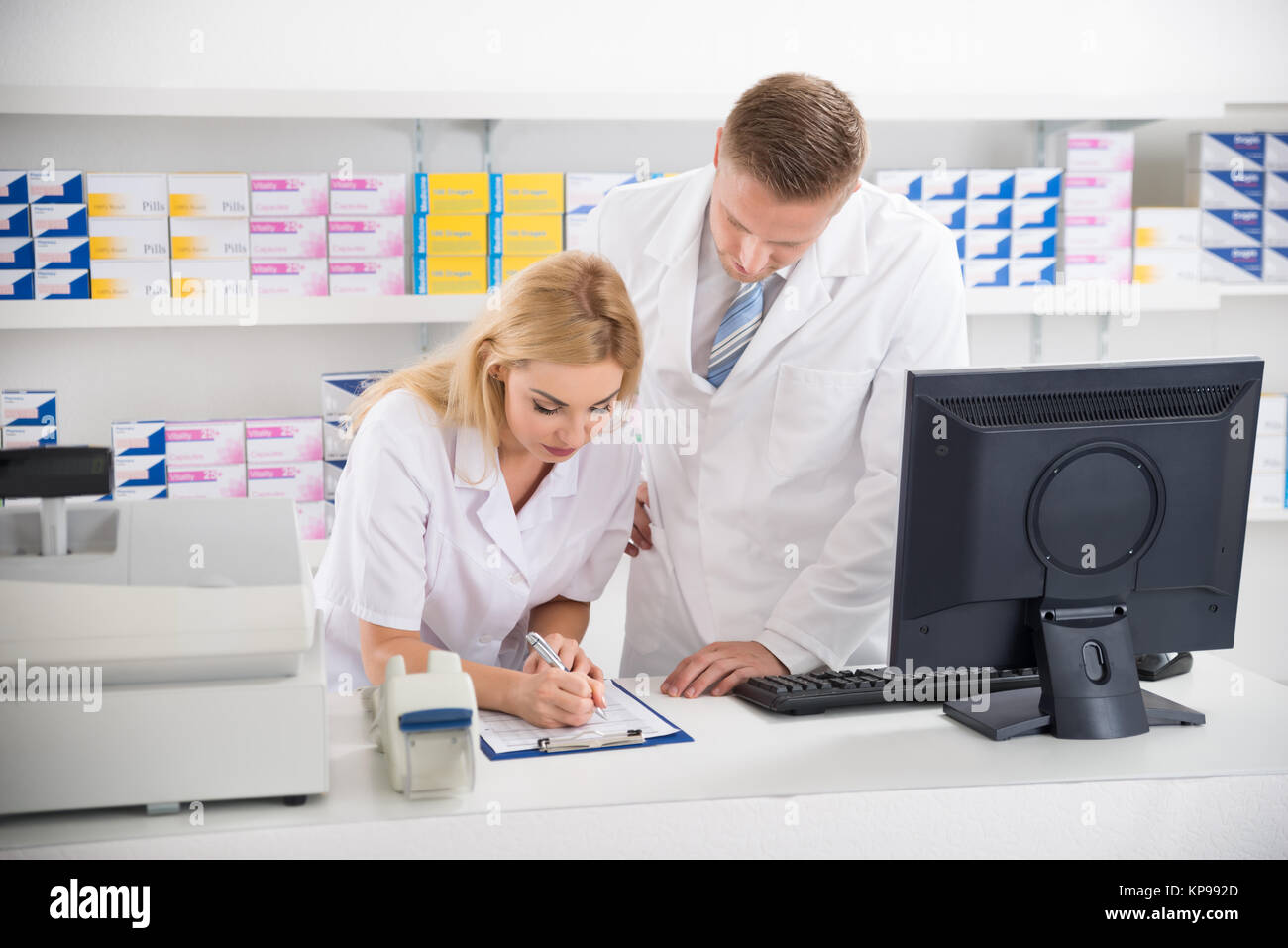 Pharmacists Maintaining Checklist At Counter In Pharmacy Stock Photo ...
