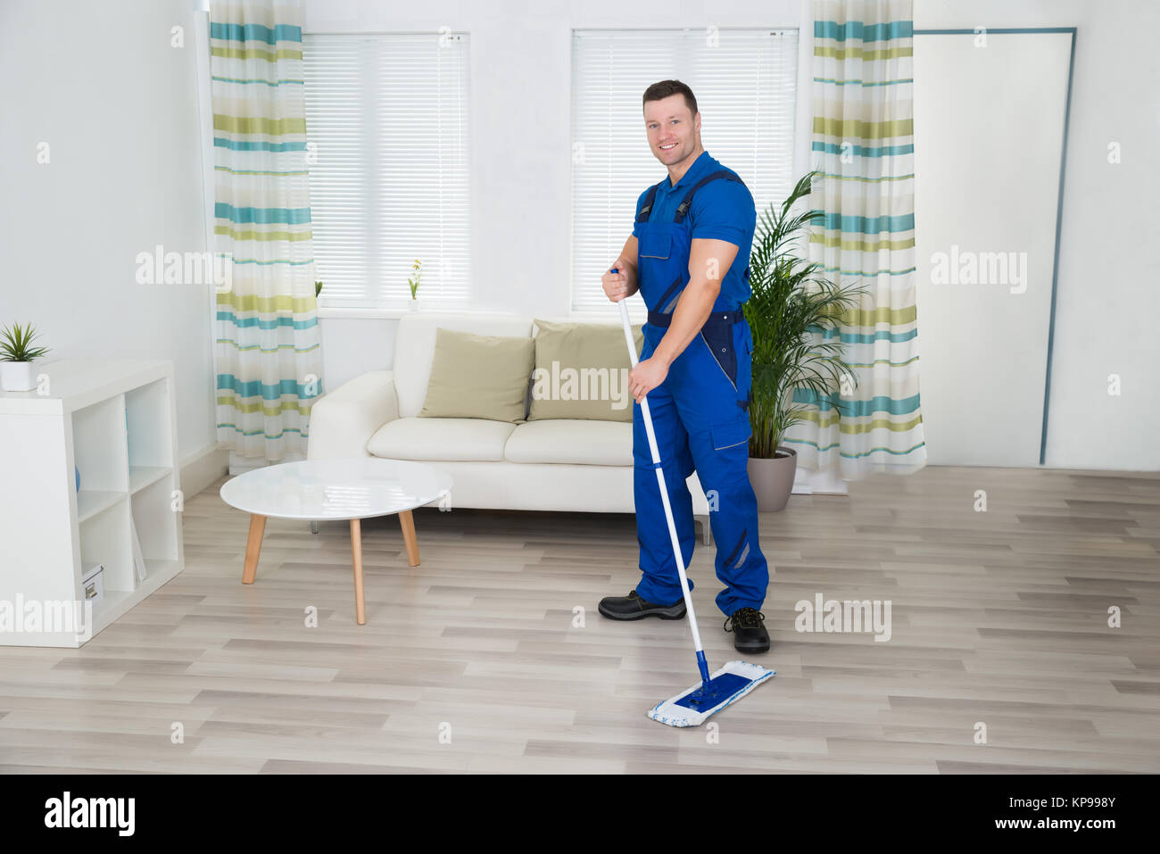 Smiling Worker Cleaning Floor With Mop At Home Stock Photo - Alamy