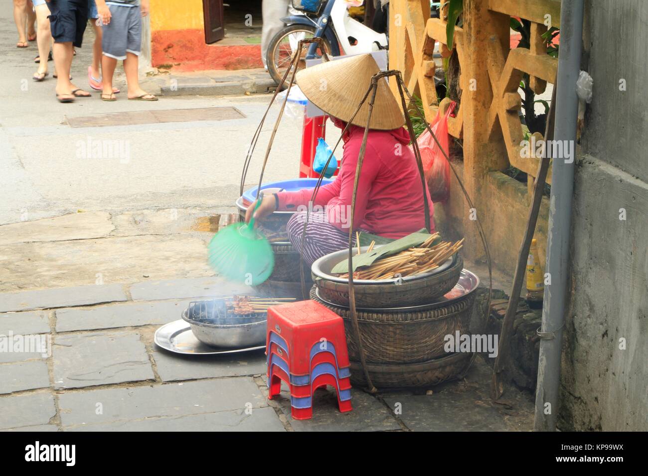 Woman fanning grill to cook street food, Hoi An, Vietnam Stock Photo ...