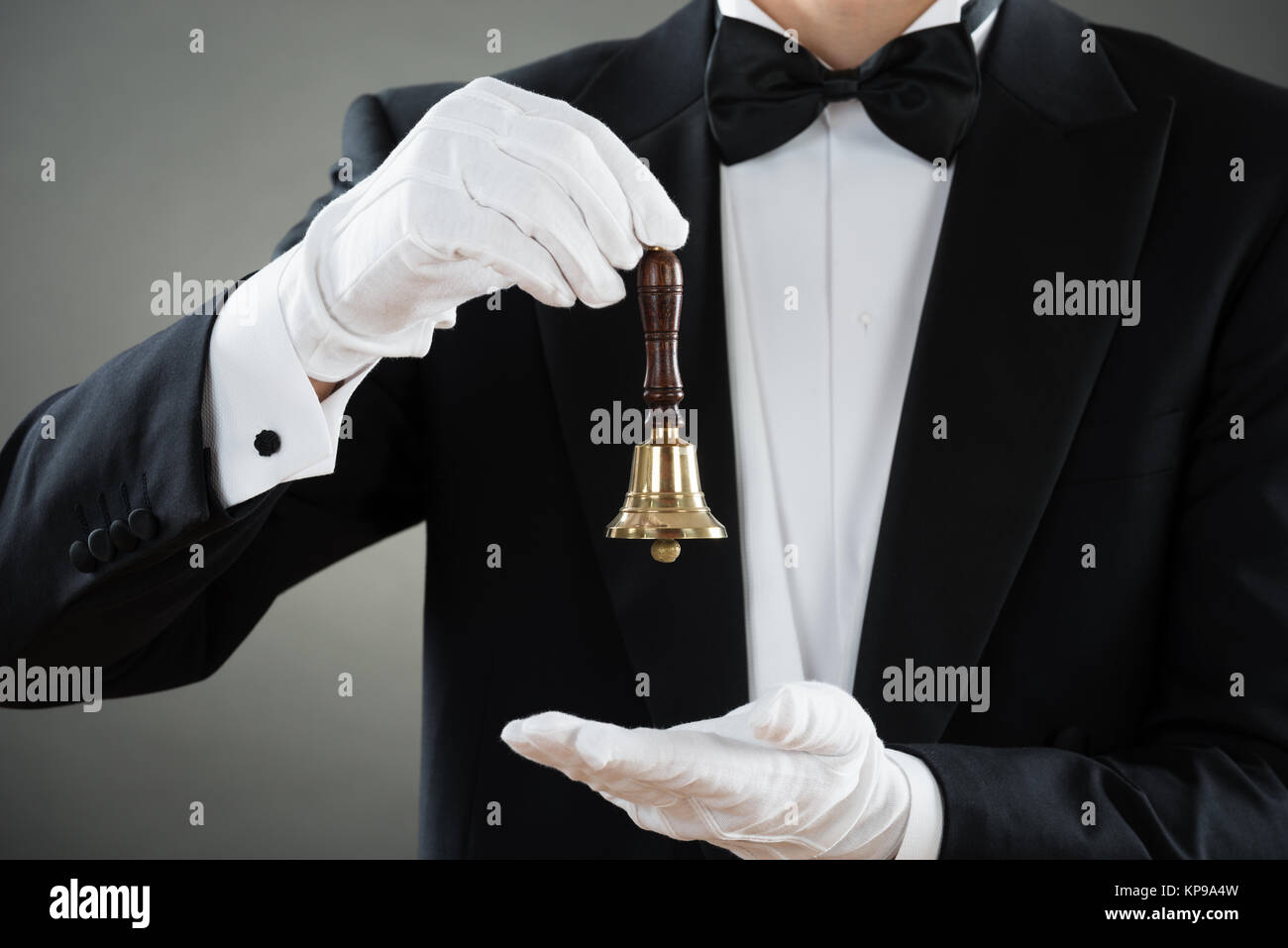 Midsection Of Waiter Holding Ring Bell Stock Photo - Alamy