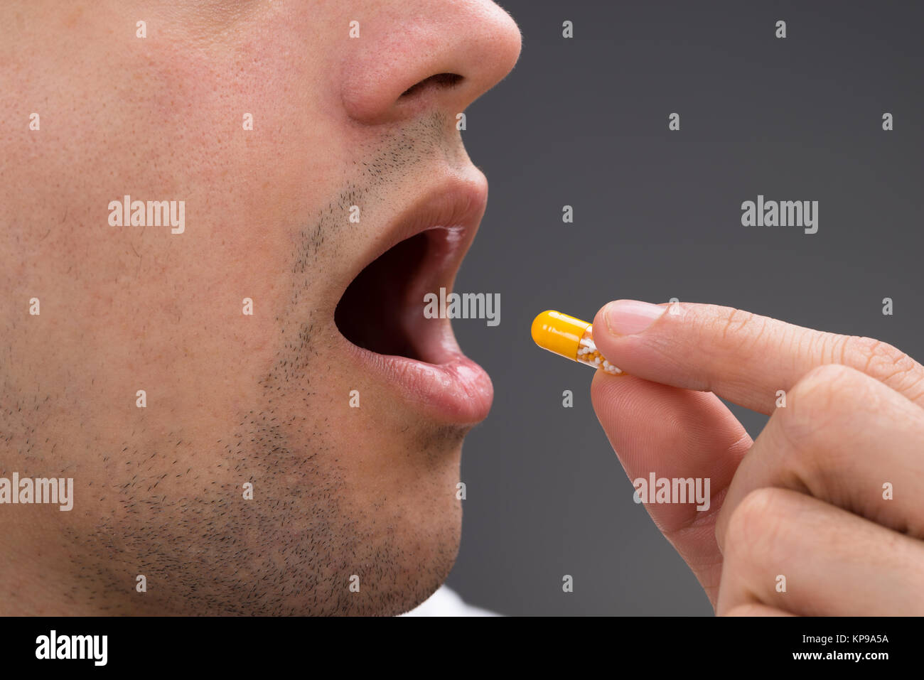 Man Taking Medicine Against Gray Background Stock Photo - Alamy
