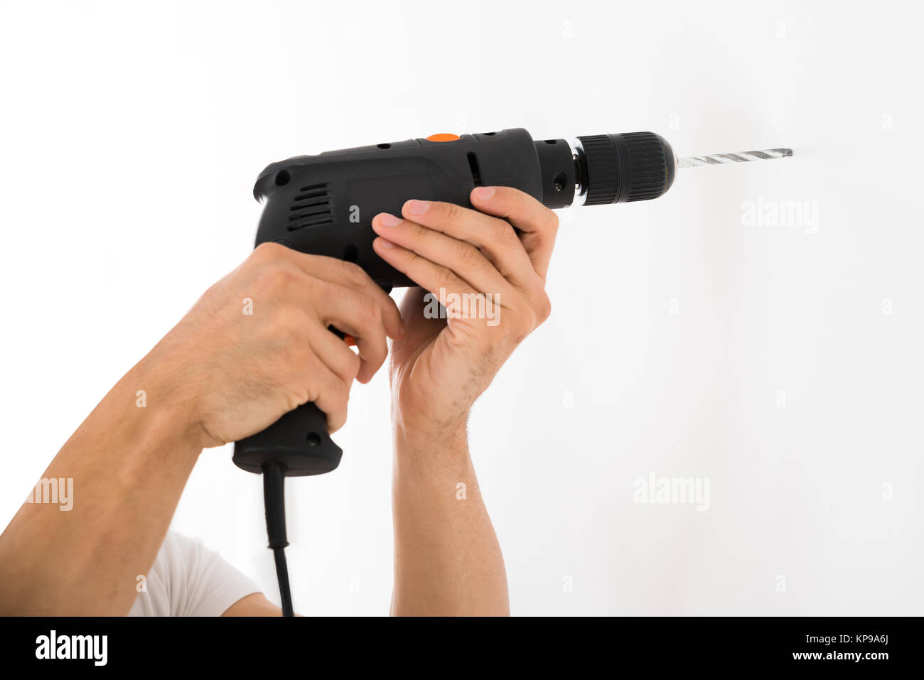 Man Using Power Drill On White Wall At Home Stock Photo - Alamy