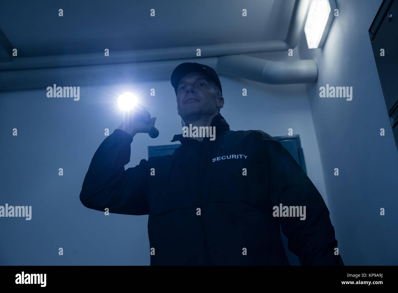 Security Guard Searching With Flashlight In Office Stock Photo - Alamy