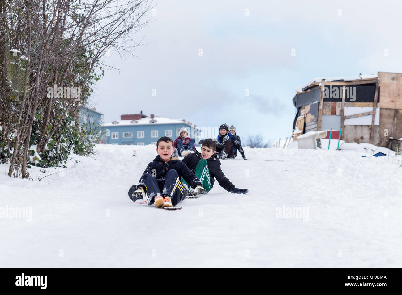 Children slide on snow in old school style with hardwood sled in ...
