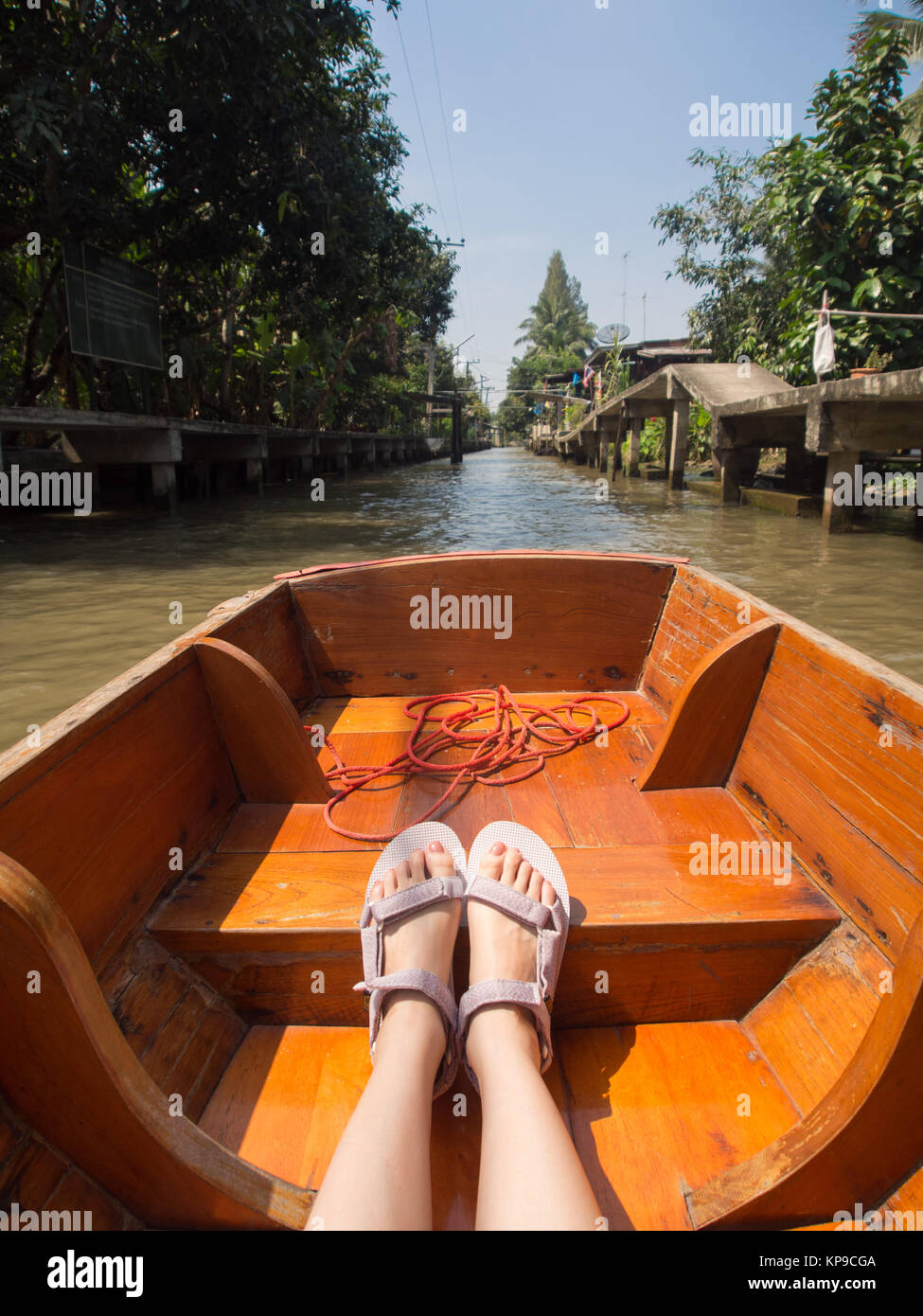 young woman wearing sandals sitting on canal boat and enjoying river ...