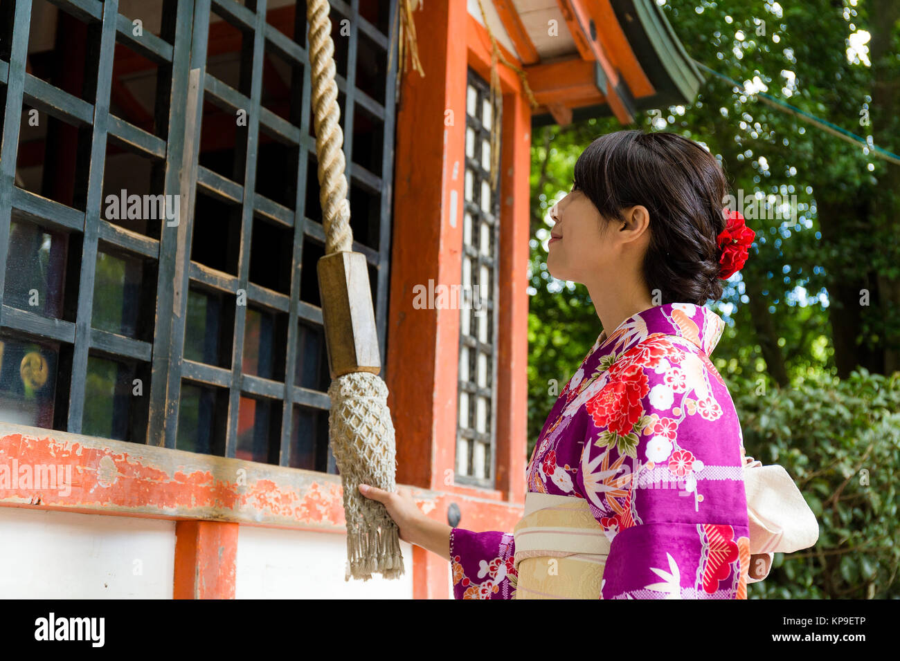 Asian Woman pull the rope to ring the bell at temple Stock Photo - Alamy