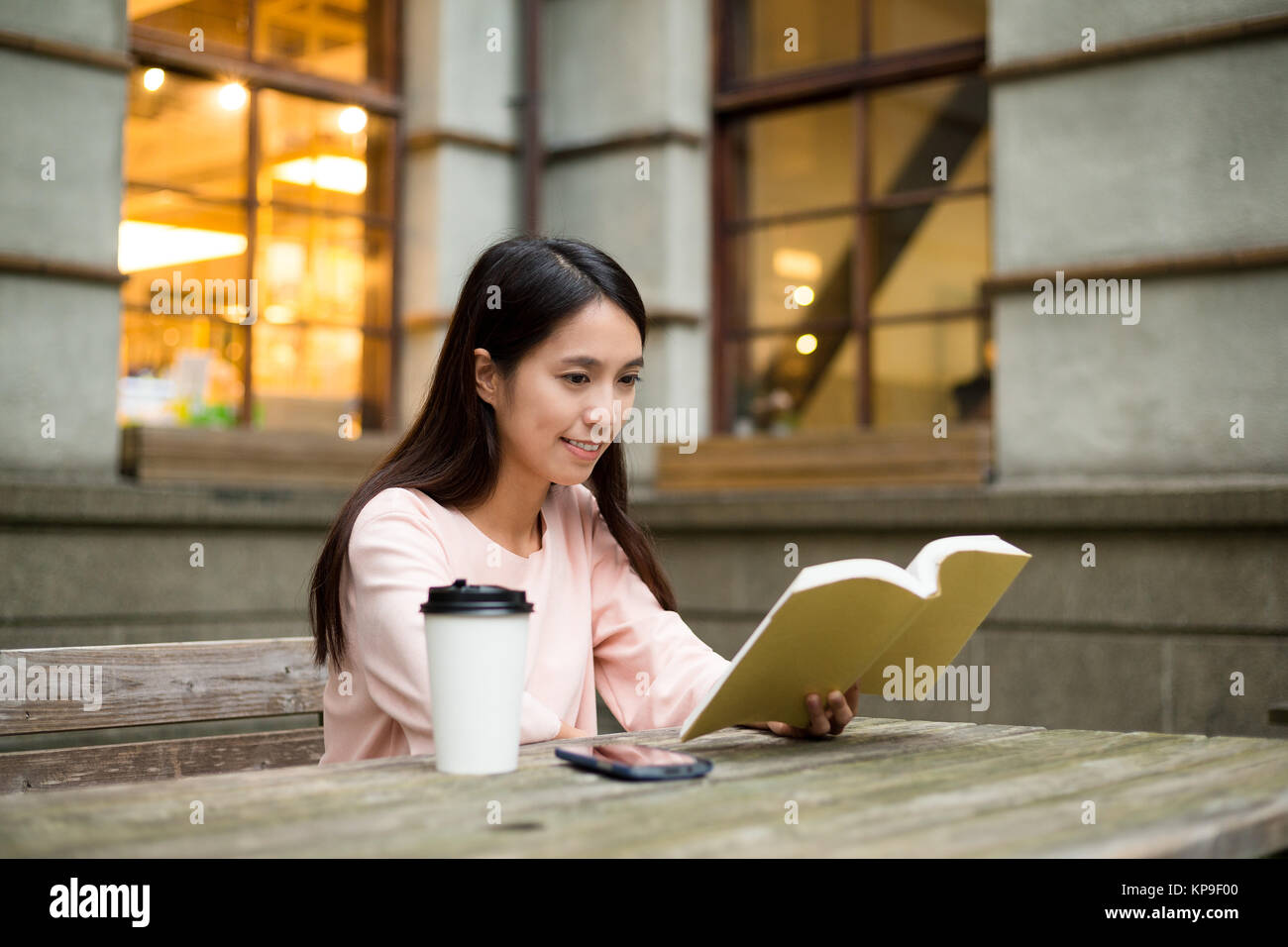 Asian Woman reading book at outdoor cafe Stock Photo - Alamy