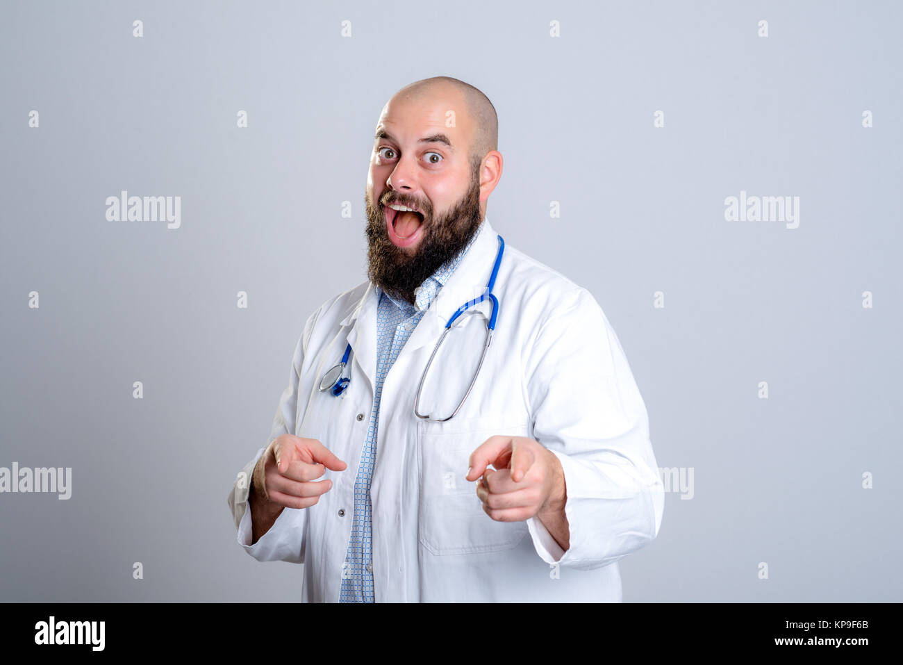 young bearded doctor in white coat smiling and pointing in to the ...