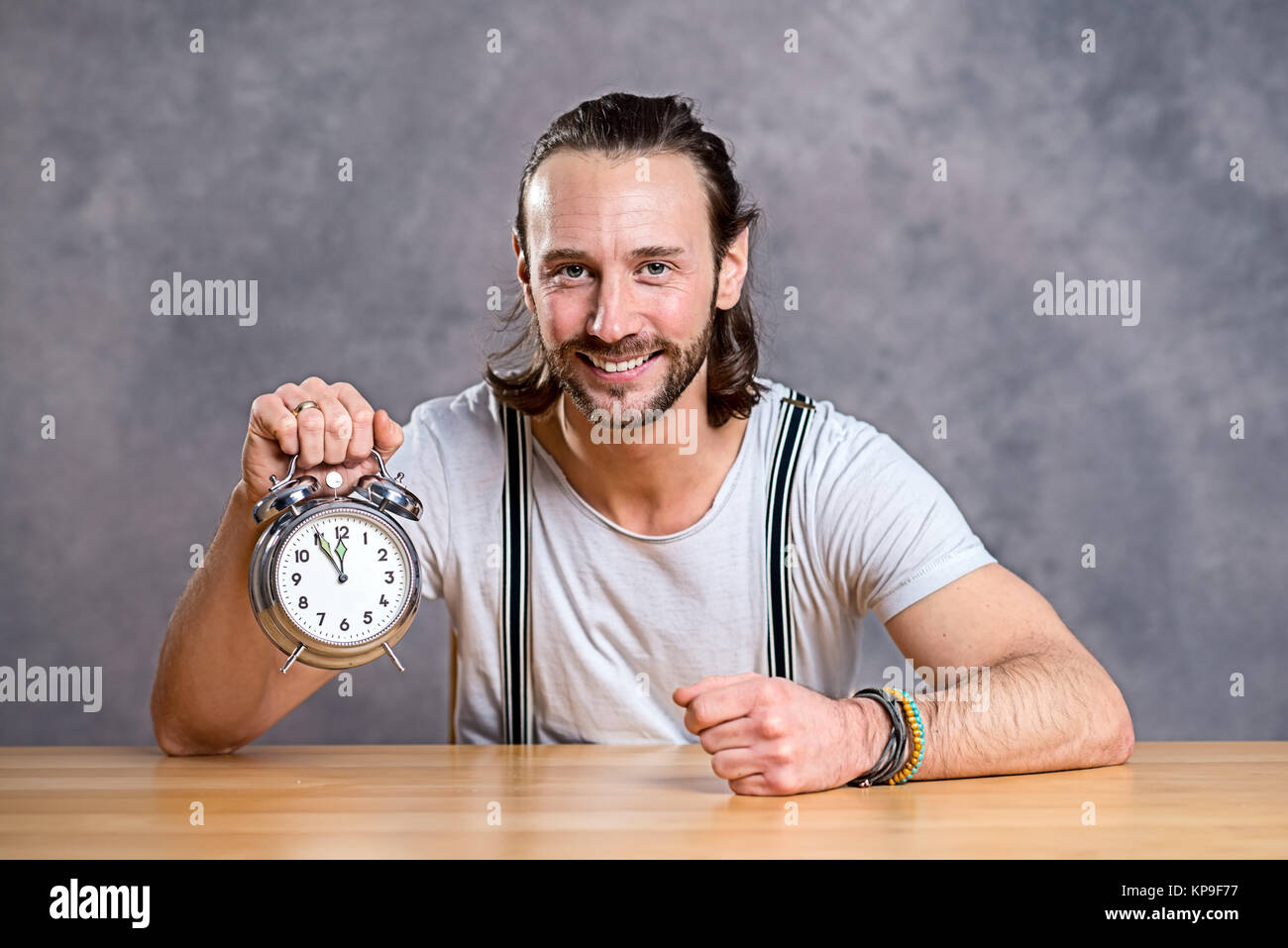 young man man with clock in front of gray background Stock Photo - Alamy