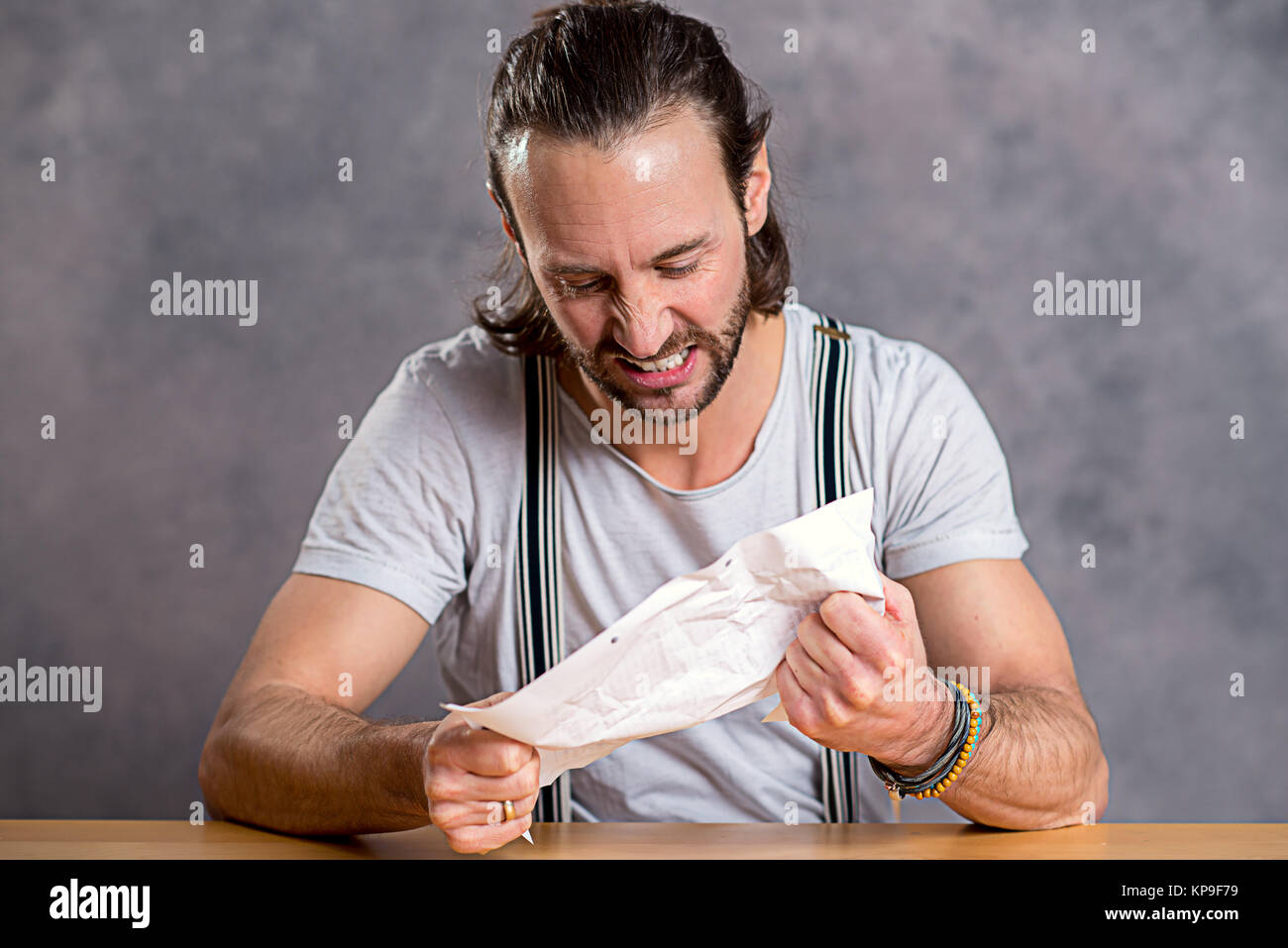 young man is annoyed about a letter Stock Photo - Alamy