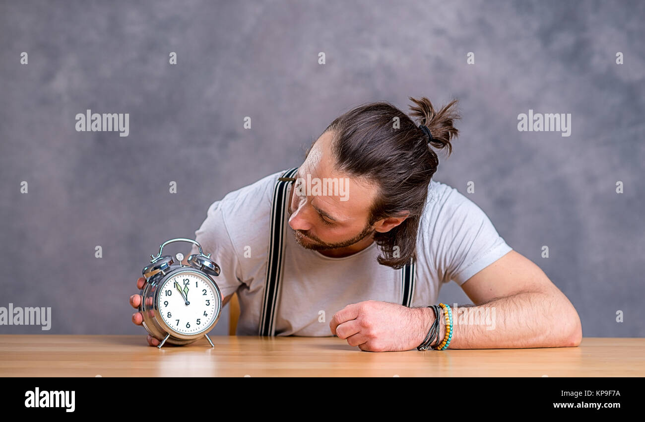 young man man with clock in front of gray background Stock Photo - Alamy