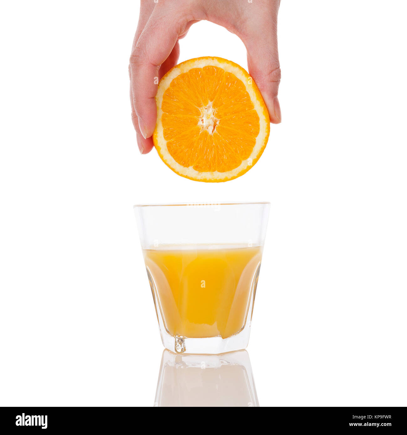 Freshly squeezed orange juice. Female hand squeezing orange into a ...