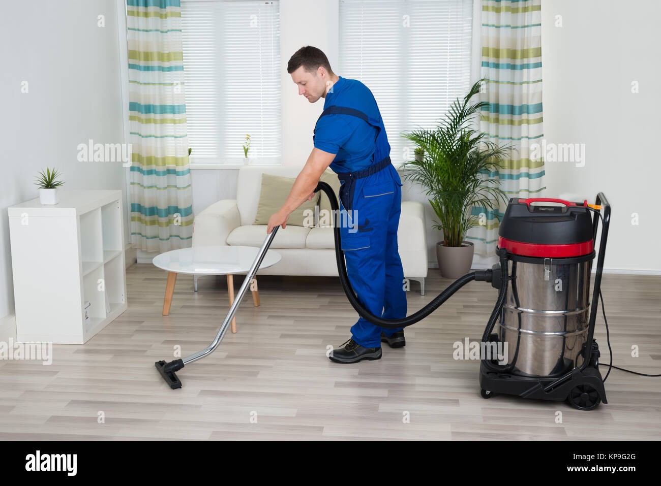 Worker Cleaning Floor With Vacuum Cleaner At Home Stock Photo - Alamy